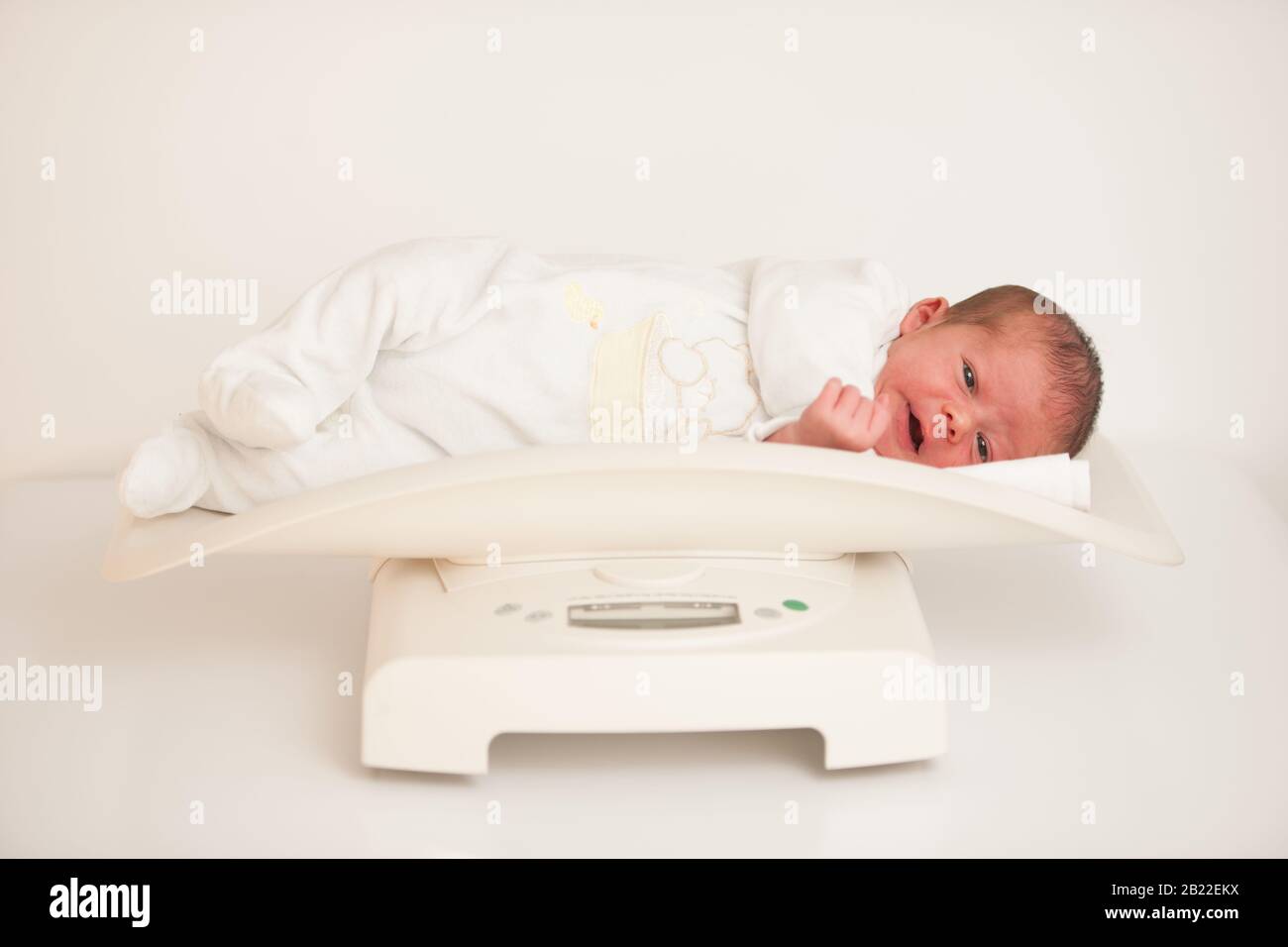 Ten days old new born child on a scale measuring weight Stock Photo - Alamy