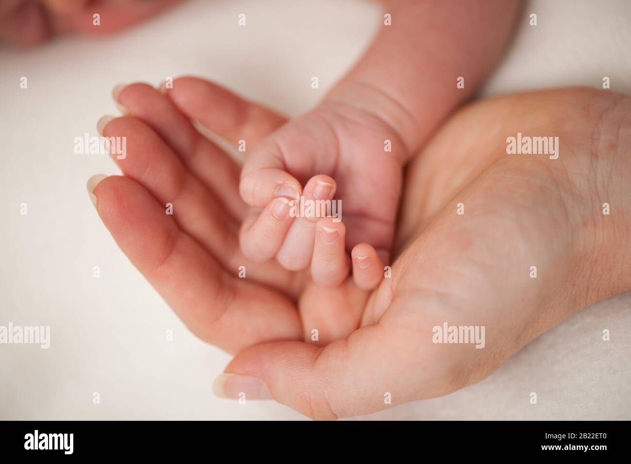 Mama holds new born hand in her hand Stock Photo - Alamy