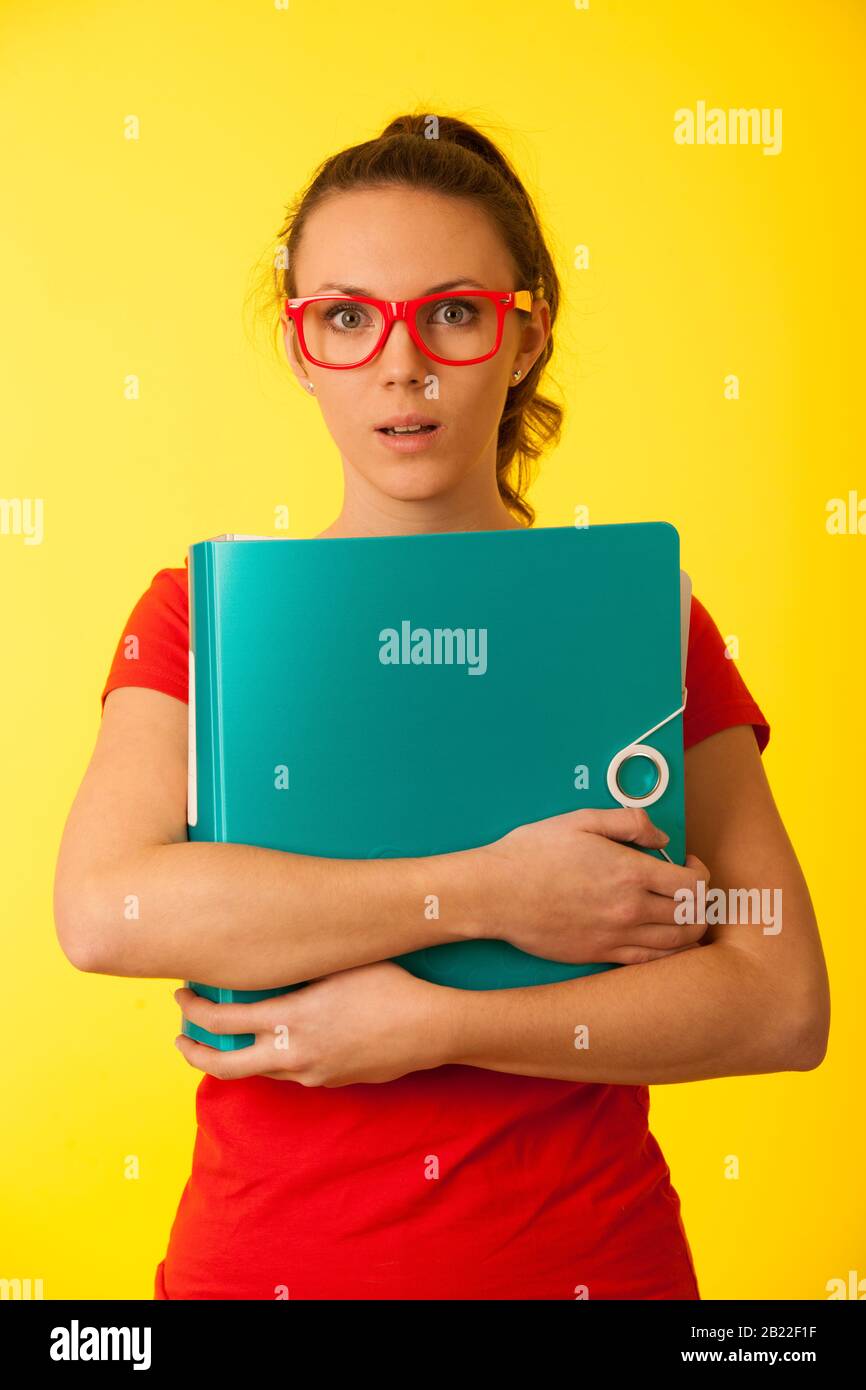 Young geek woman in red t shirt over vibrant yellow background under ...