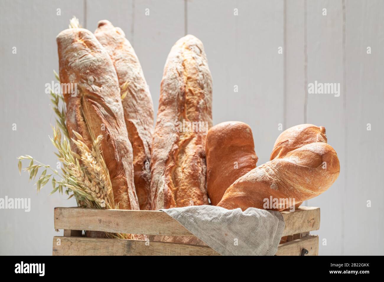 Closeup of golden baguettes with grains in wooden box Stock Photo - Alamy
