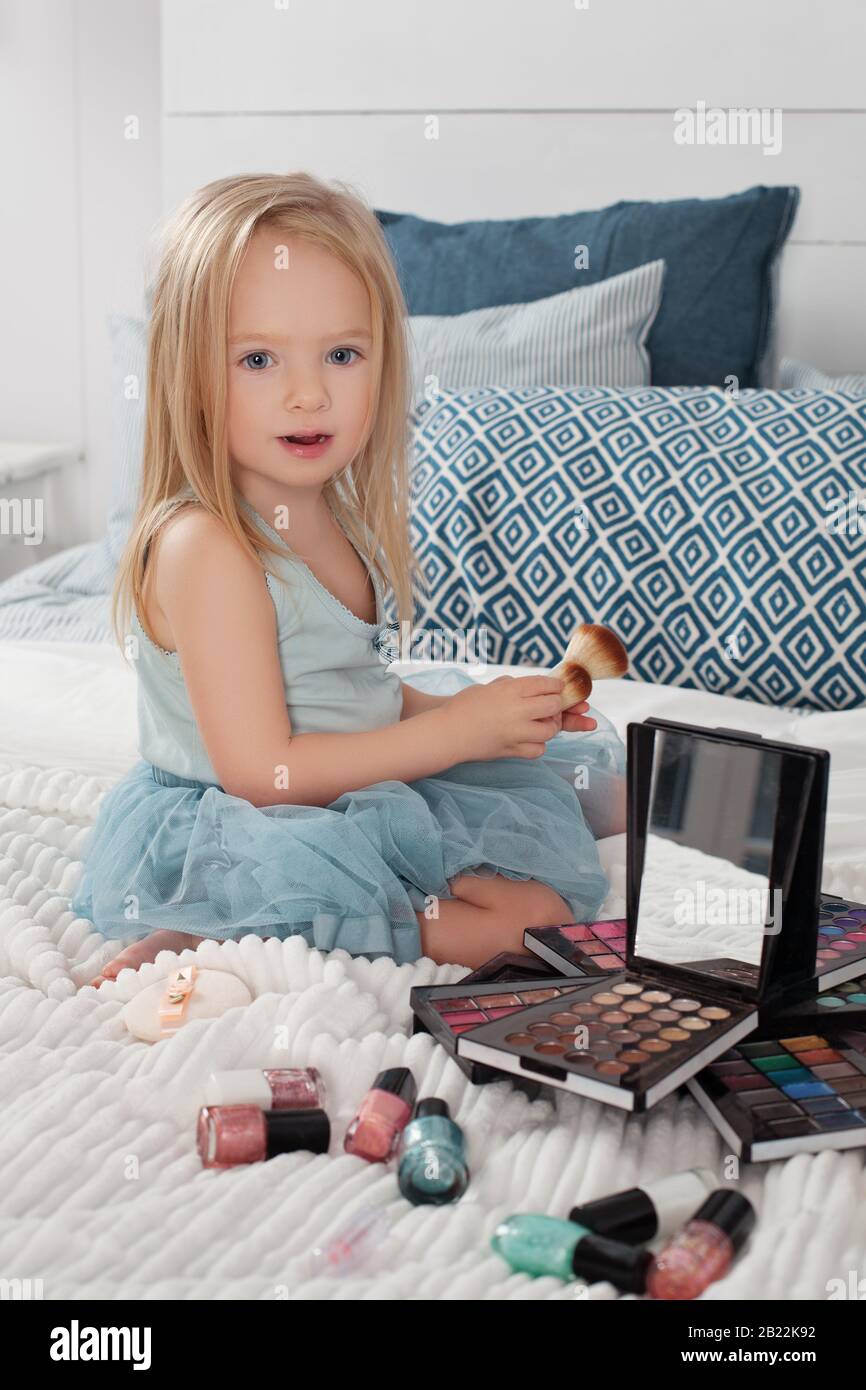 Pretty little girl and makeup cosmetics at home Stock Photo - Alamy
