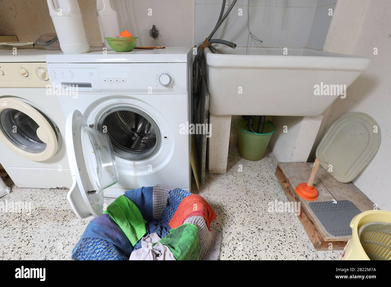 two washing machines and a sink in the laundry area Stock Photo - Alamy