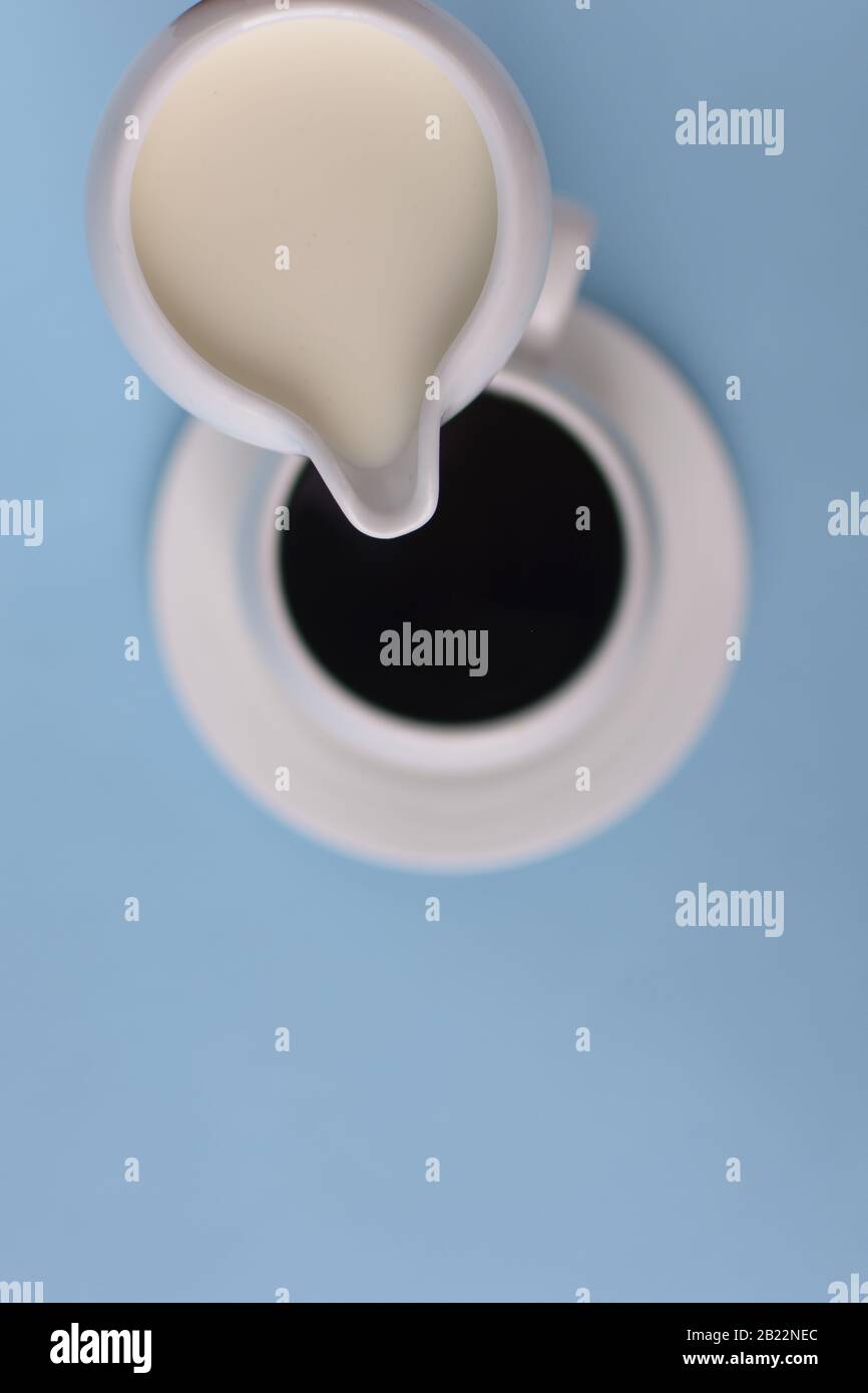 Pouring milk from small ceramic pitcher into a cup of coffee Stock ...