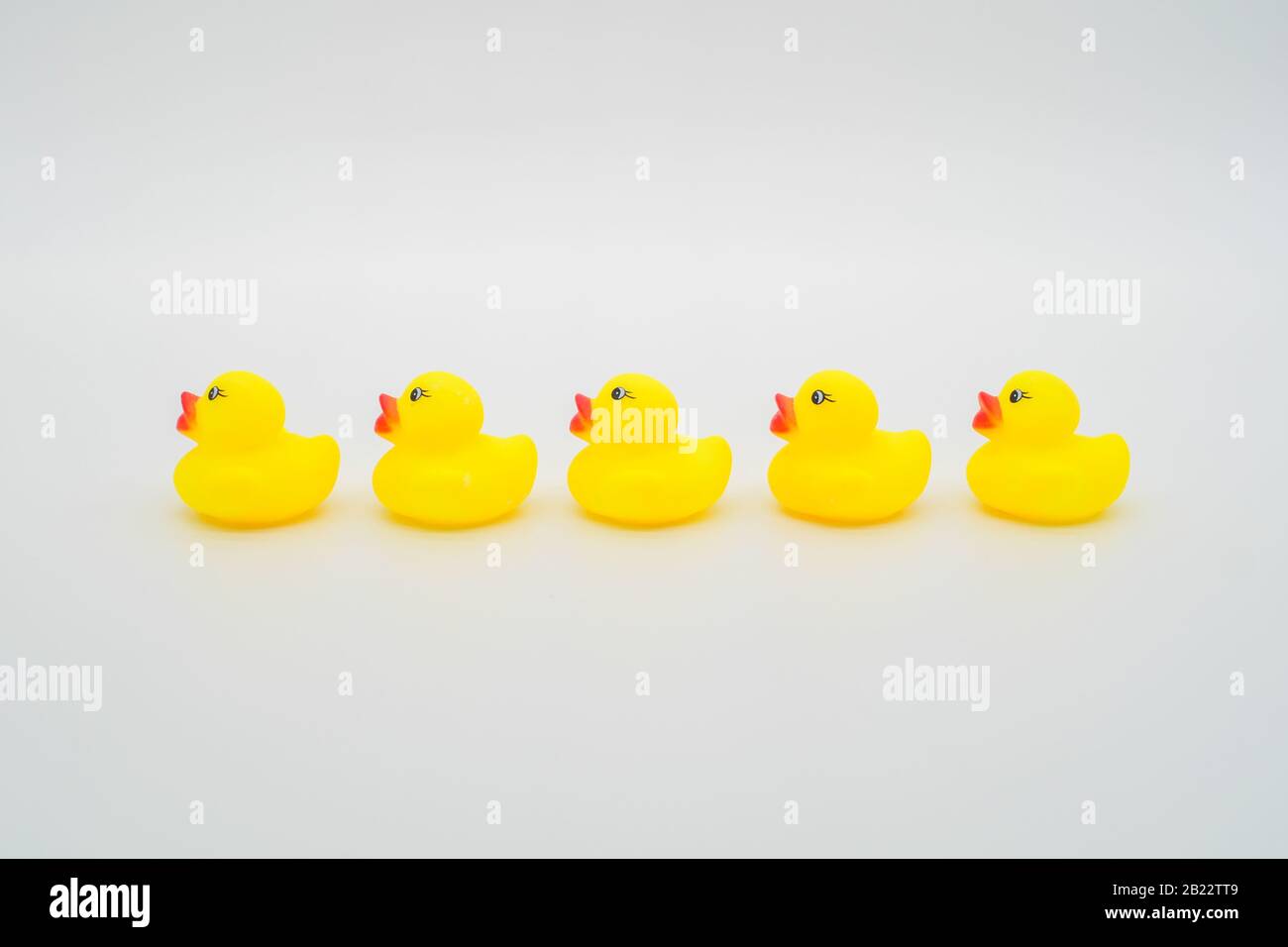 Five mini yellow rubber ducks in a row. Isolated on white background ...