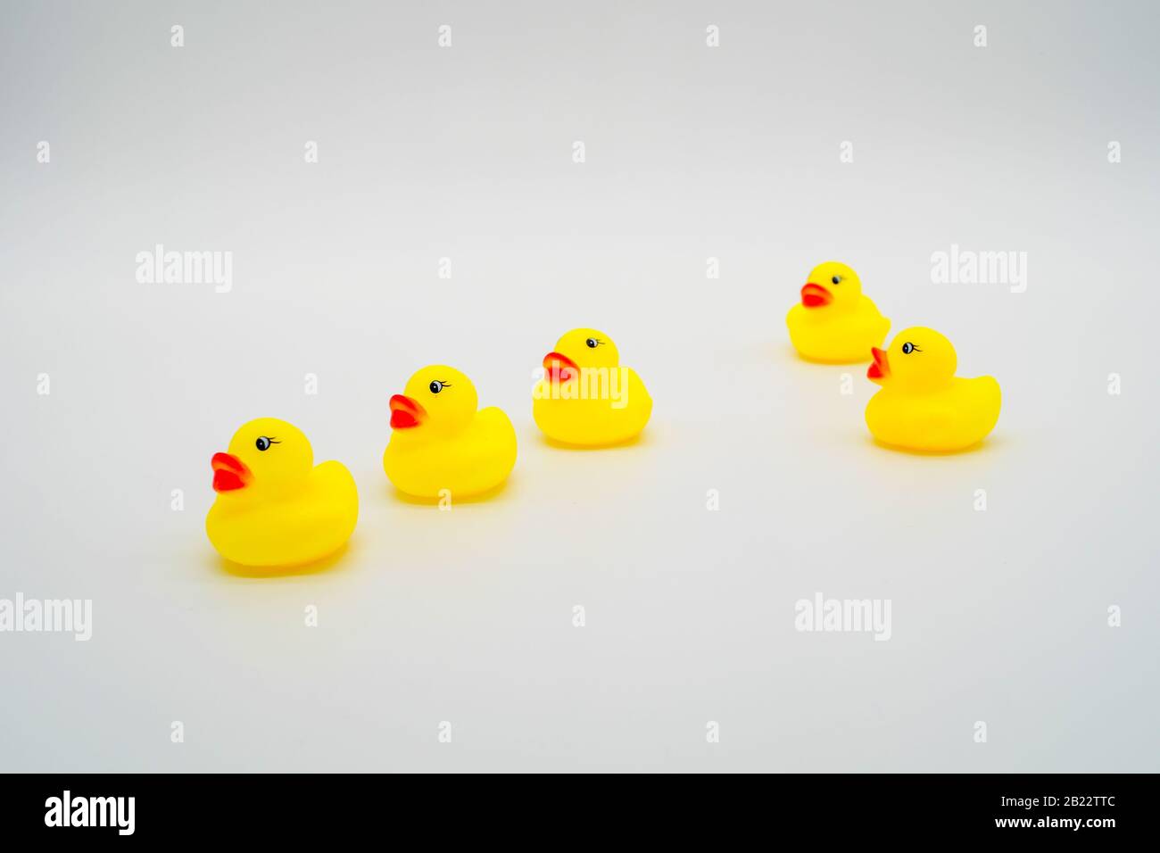 Five mini yellow rubber ducks in a row. One duck making their way into ...
