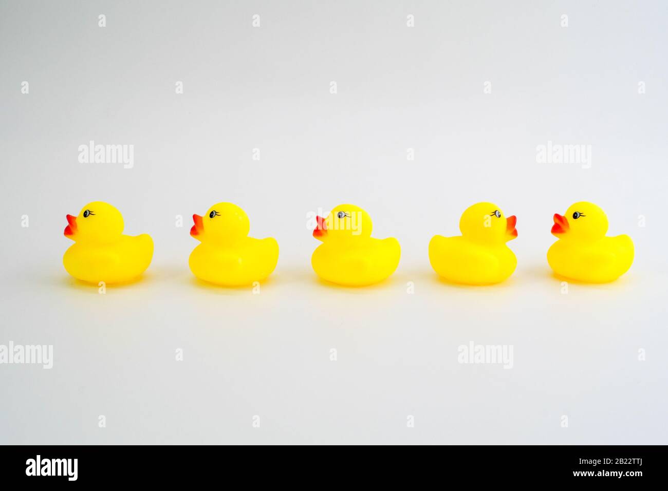 Five mini rubber ducks in a row. Two facing each other talking. Getting ...
