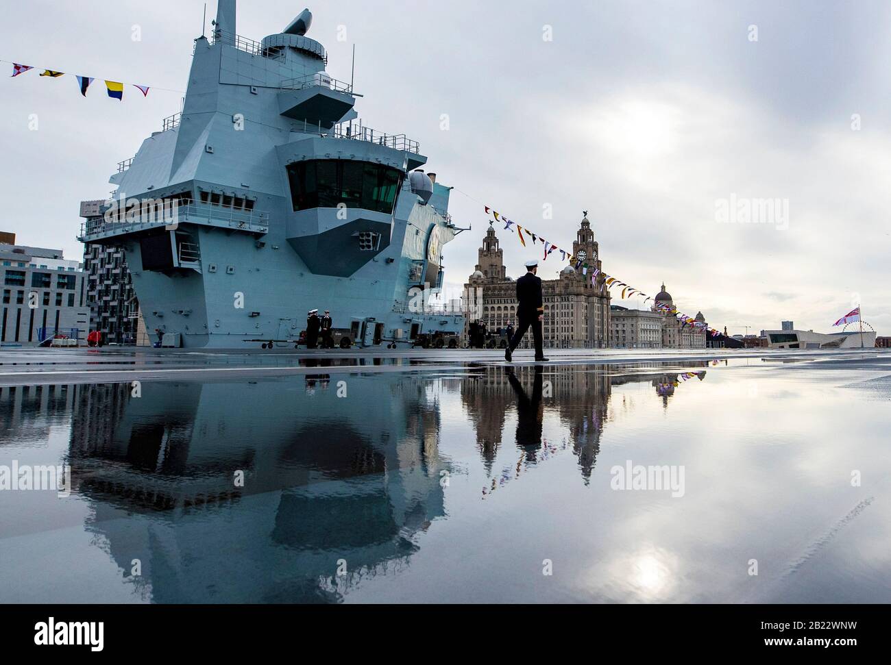 The Royal Navy aircraft carrier HMS Prince of Wales sits in front of ...