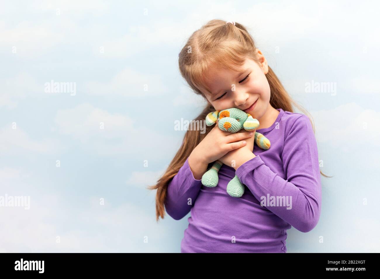 Little girl, happy child holding her stuffed cuddle rag toy close to ...