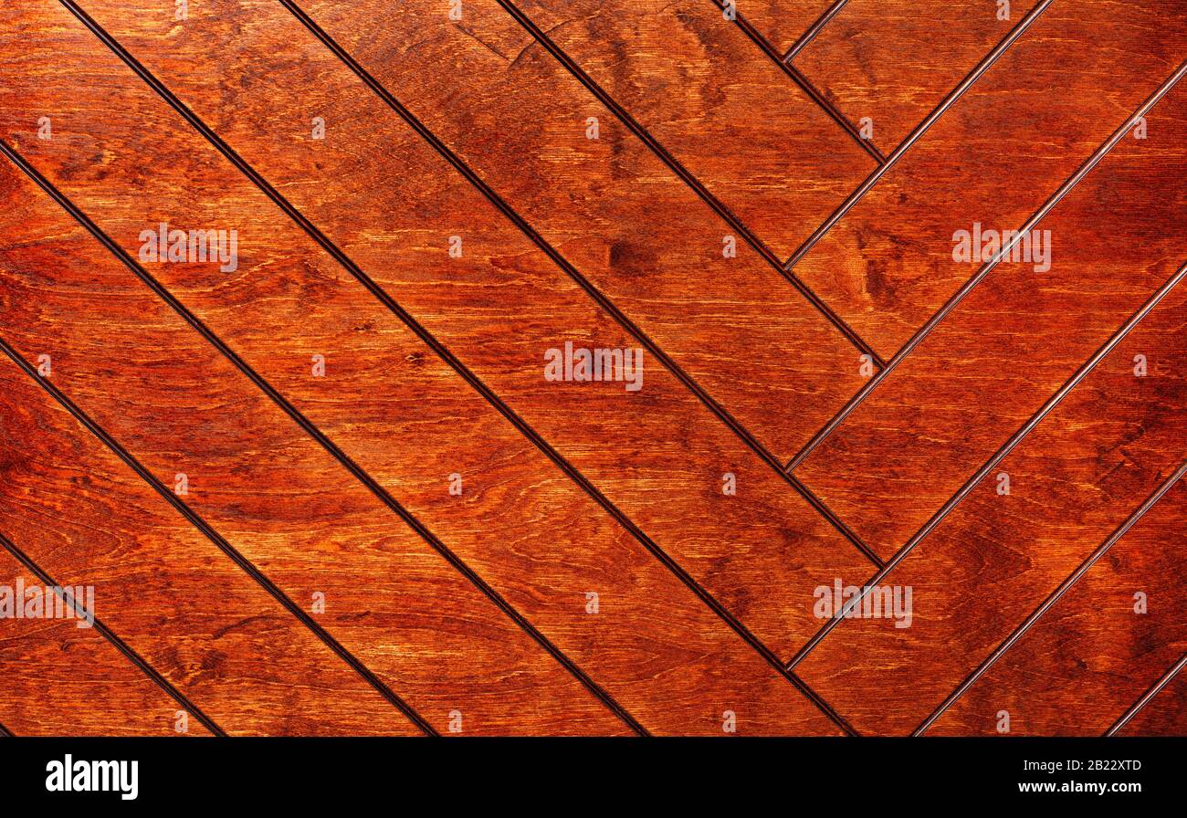 Old wooden boards painted with orange paint form a herringbone pattern ...
