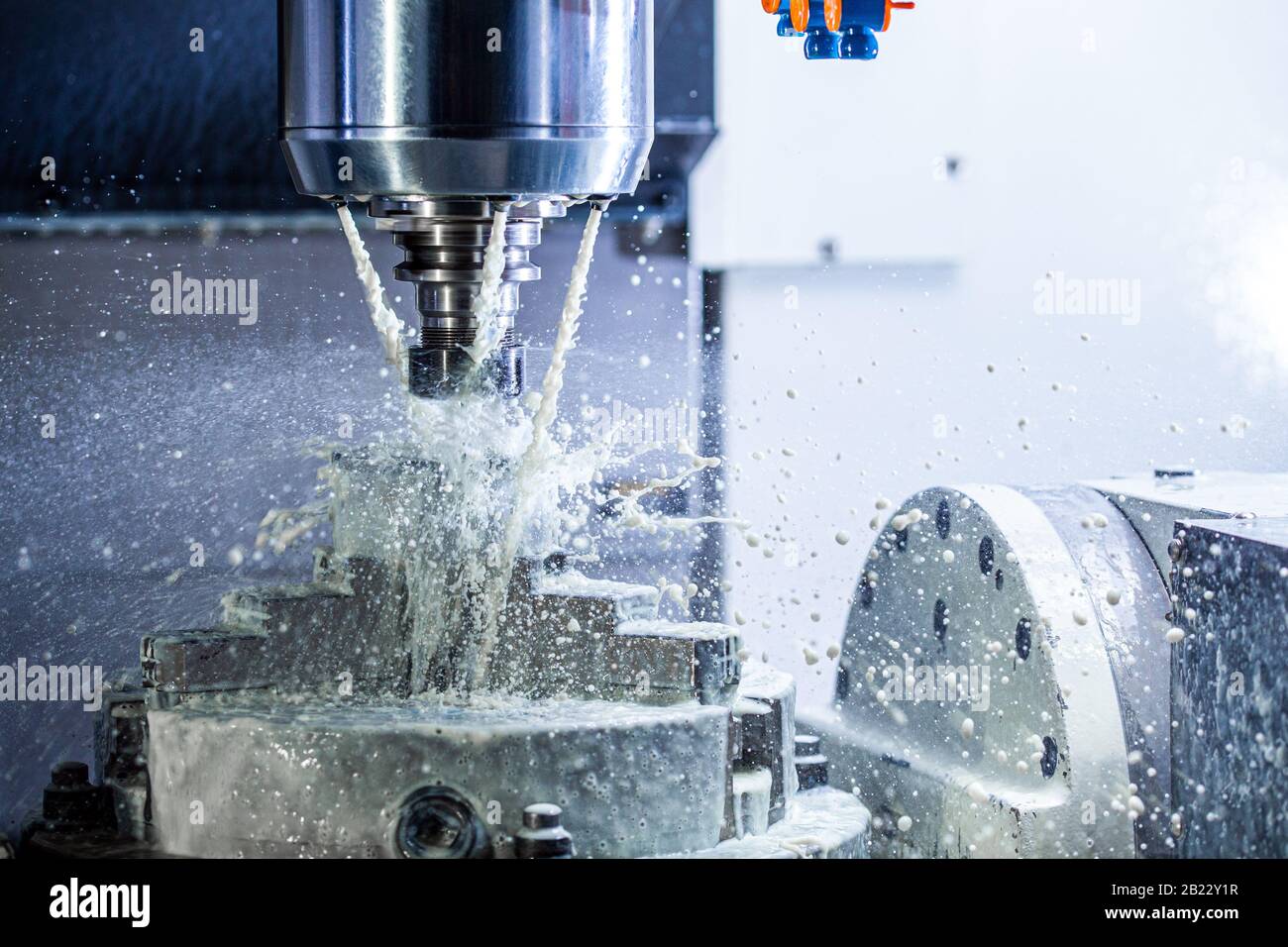 a process of industrial wet milling in 5-axis cnc machine with coolant ...