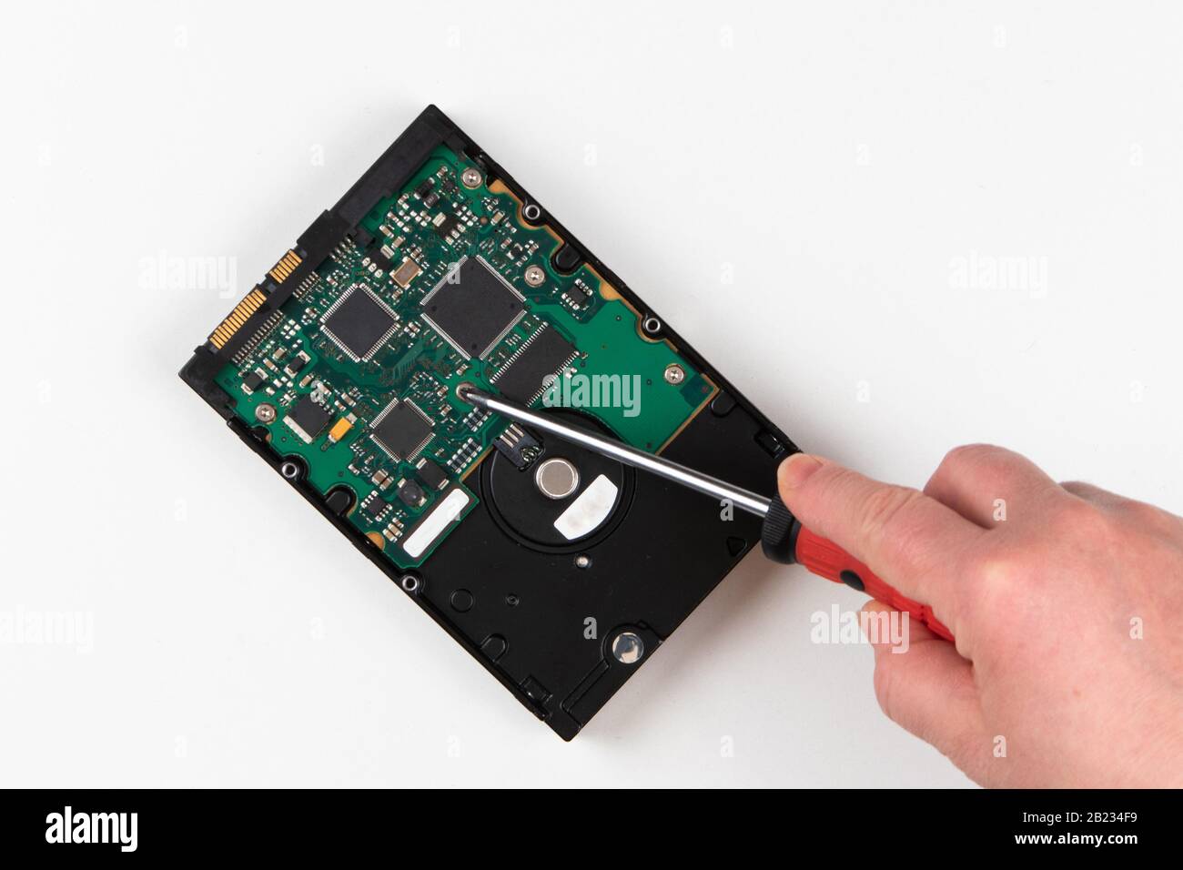 IT specialist with screwdriver repairing old computer hard disk, image ...
