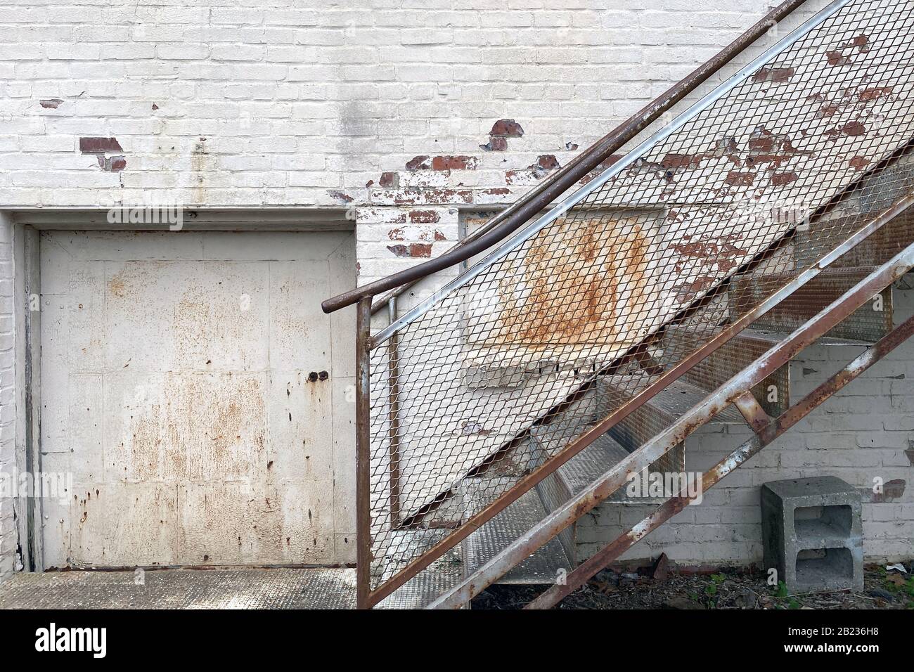 an alley warehouse loading and receiving door with rusted stairs to ...