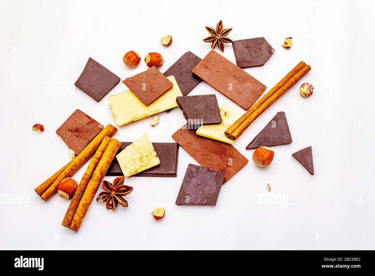 Assortment of different chocolate types, spices and hazelnuts above ...