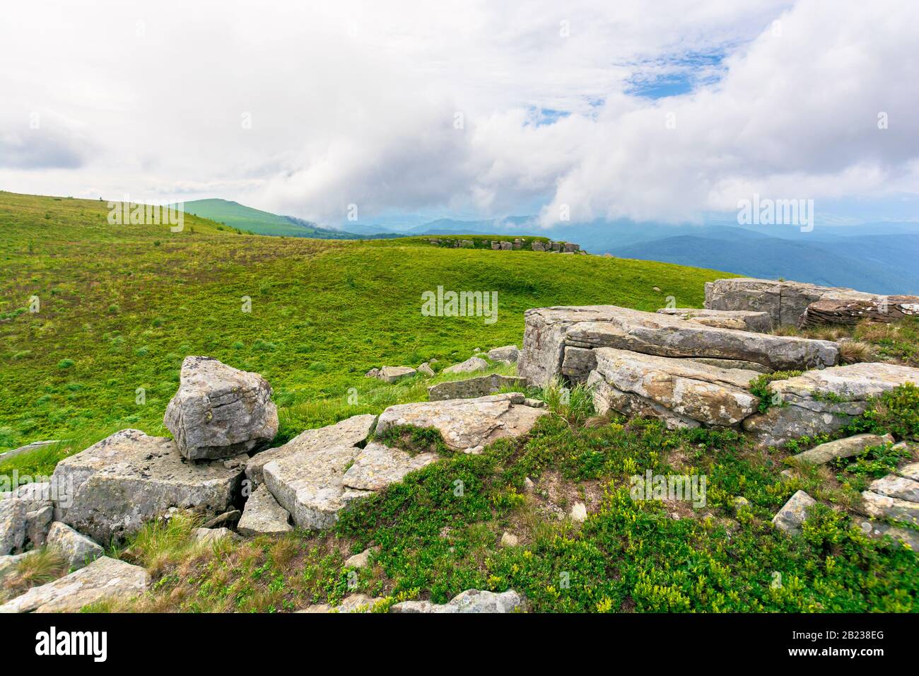 rock on the meadow. cloudy alpine summer. grass on the hills, slopes ...