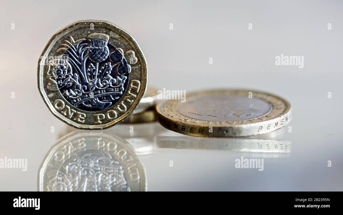 UK Pound coins and a £2 coin shot macro on a reflective surface Stock ...