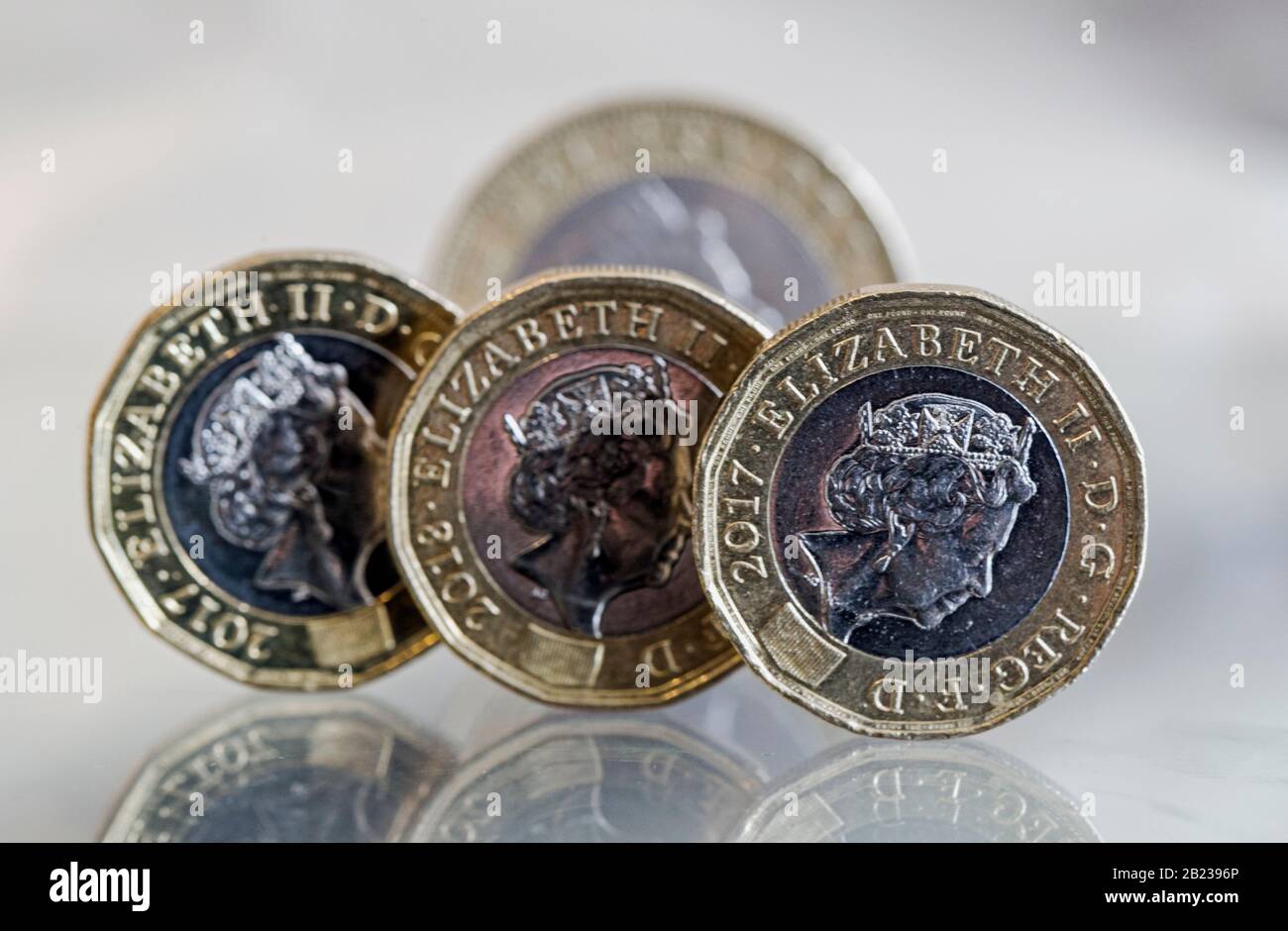 UK Pound coins and a £2 coin shot macro on a reflective surface Stock ...