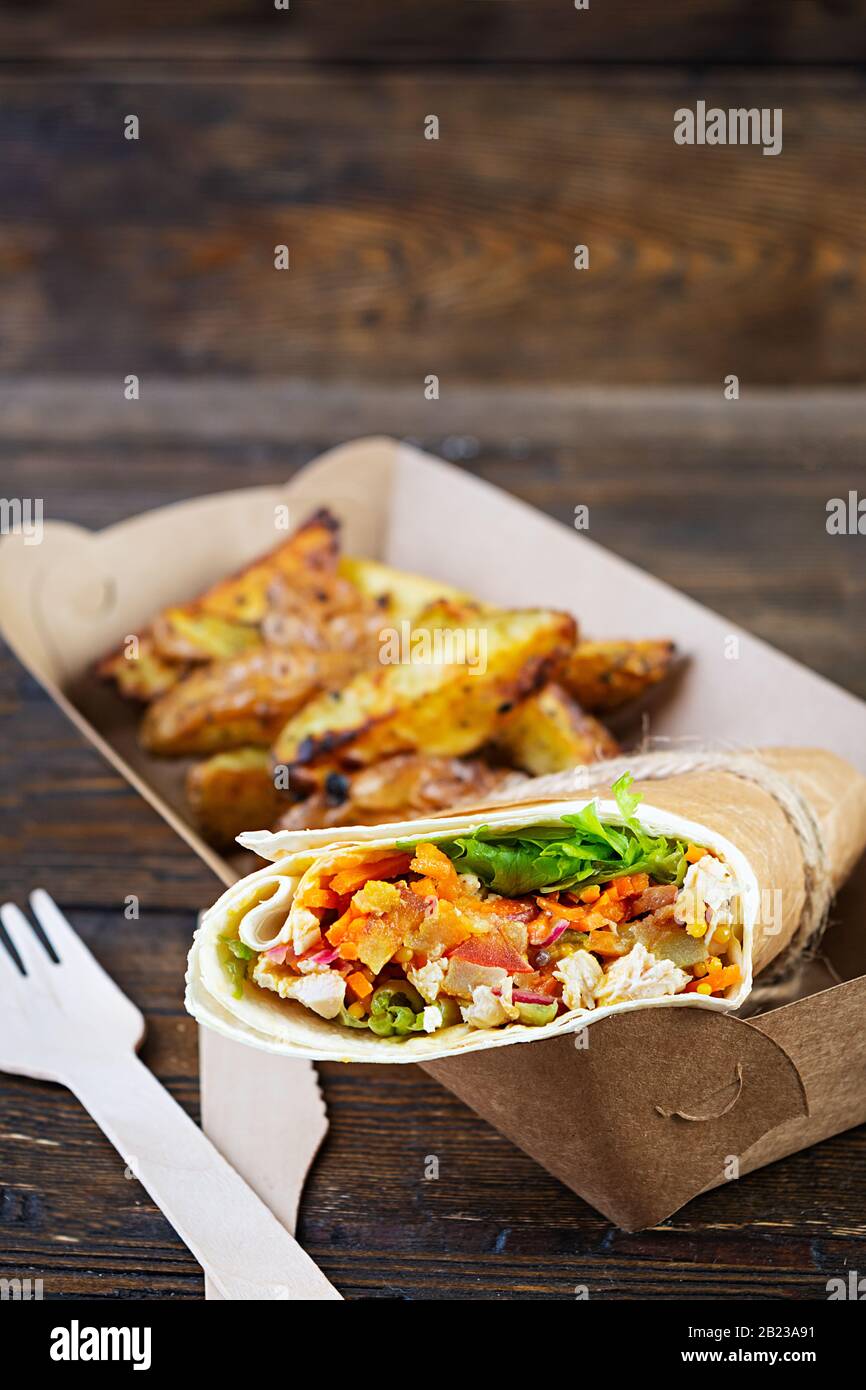 Delicious shawarma sandwich with chicken and potato on wooden ...