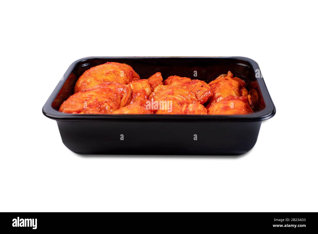 Grilled legs. Isolate.Raw chicken marinated legs in a black plastic ...