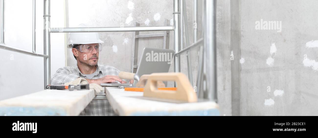man work, professional construction worker with computer, plastering ...