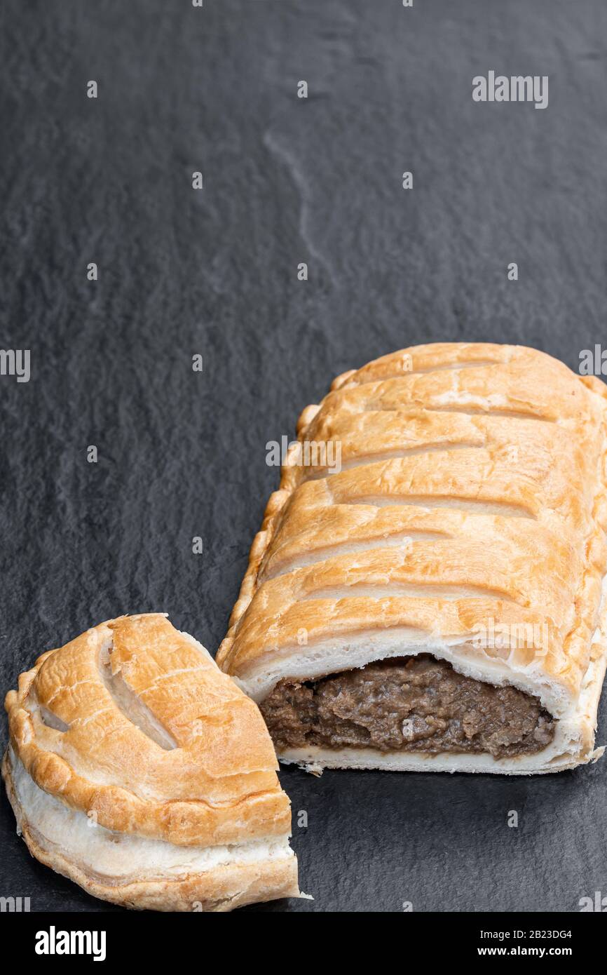 Homemade flaky pasty with mince meat filling on black stone background ...