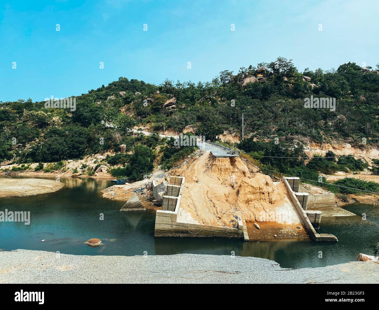 The destroyed bridge over the mountain river. Concrete bridge collapsed ...