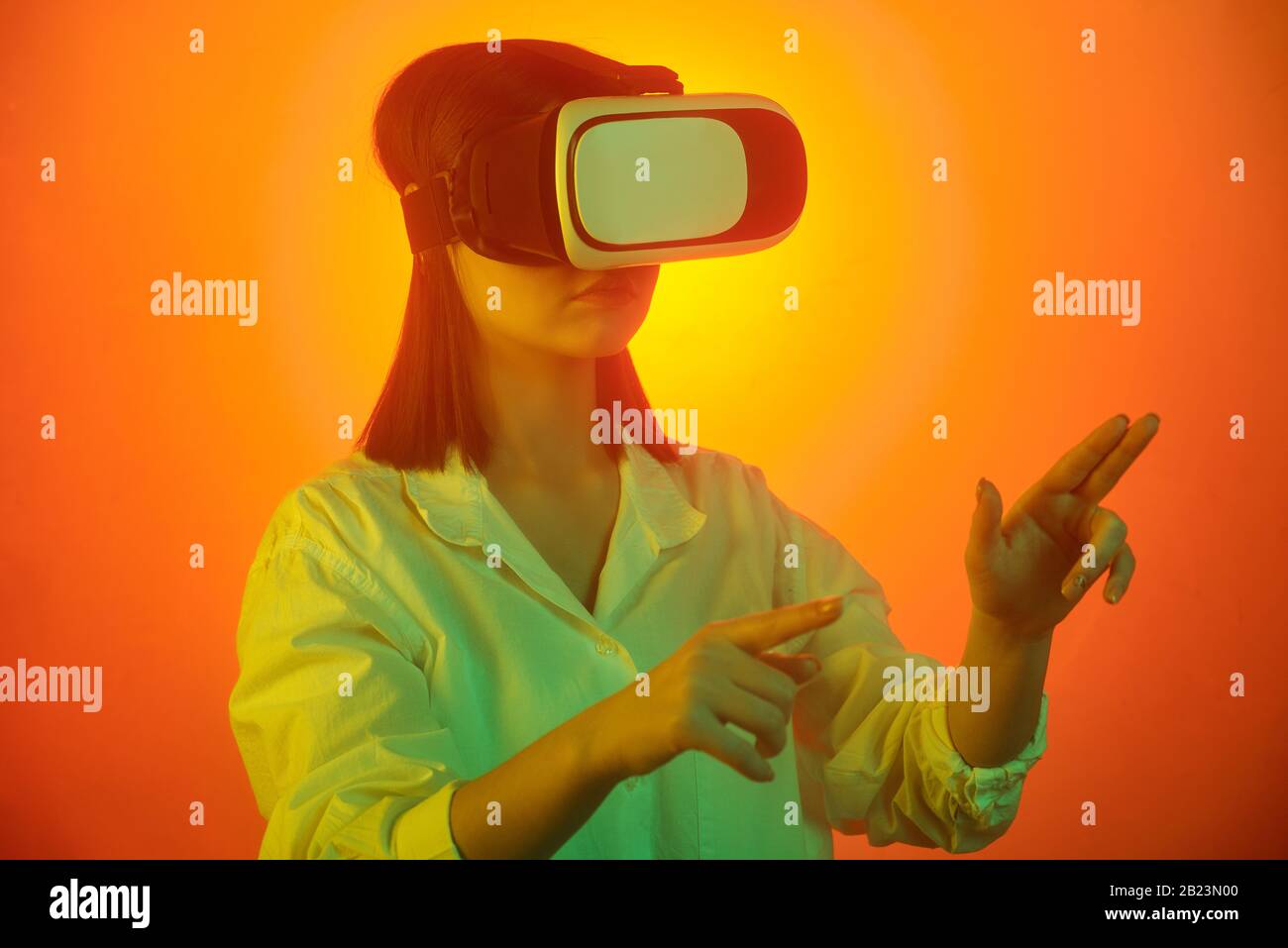 Young female student in vr headset pointing at virtual display while ...
