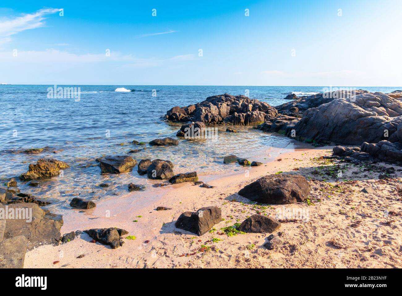 rocks on the sea beach in the morning. calm sunny weather. secluded ...