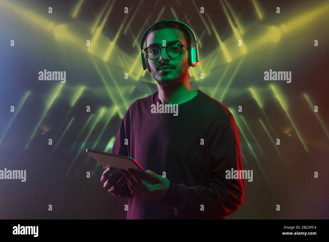 Young serious software developer in headphones using touchpad while ...
