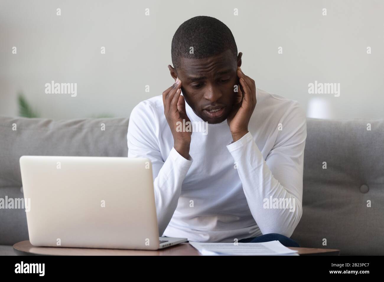 Unhappy African American man reading bad news in paper letter Stock ...