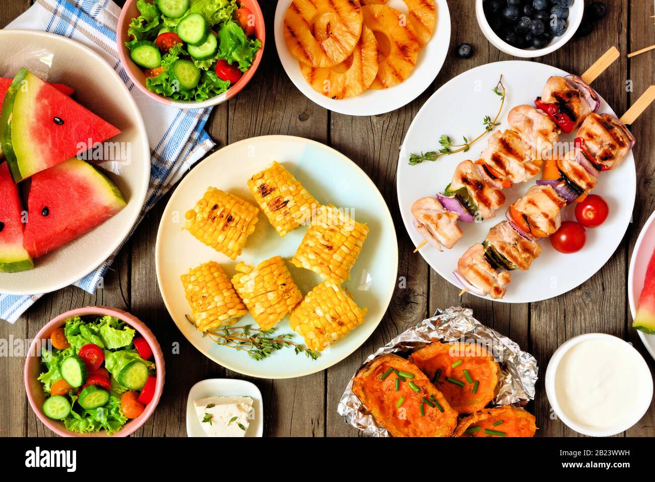 Summer BBQ or picnic food concept. Selection of fruits, salad, grilled ...