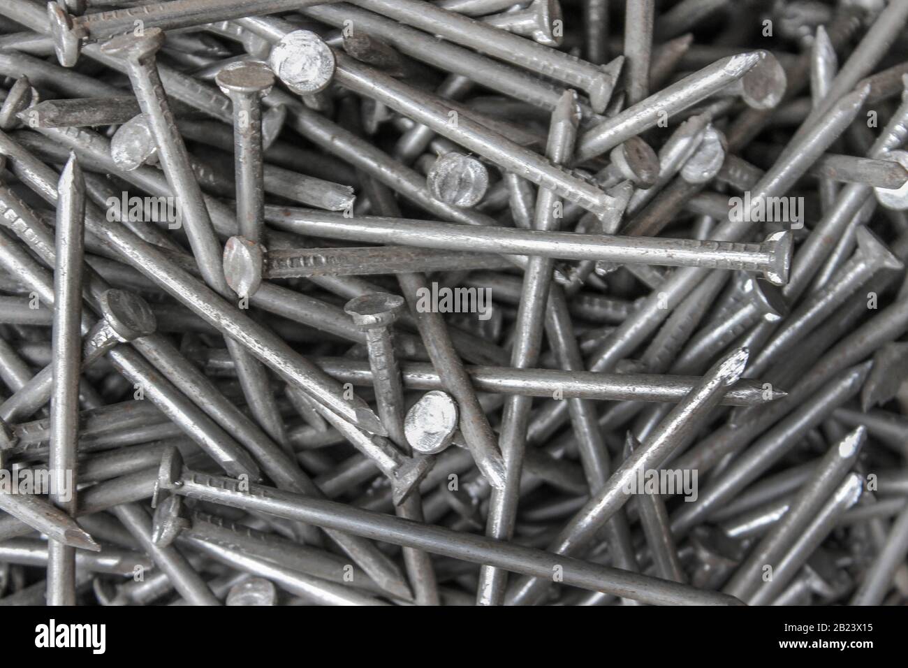 Steel nails scattered as a background Stock Photo - Alamy