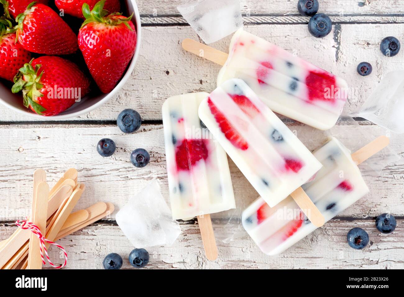 Healthy strawberry blueberry yogurt popsicles, top view summer table ...