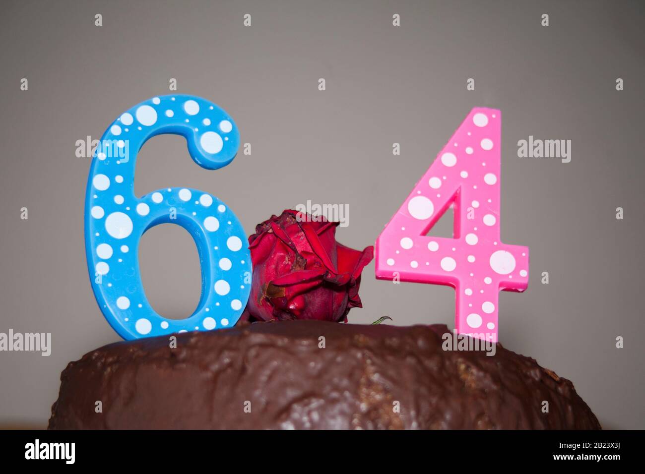 Numbers 64 on a chocolate cake. Blue 6 and rose 4 meaning 64 years ...