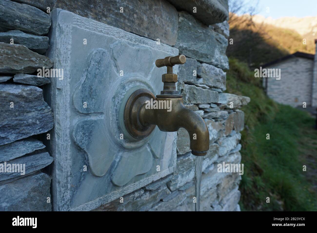 Ancient stone fountain with brass tap Stock Photo - Alamy
