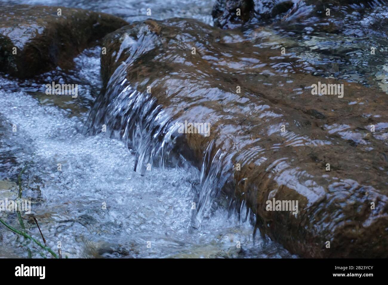 Water flows into a mountain river Stock Photo - Alamy