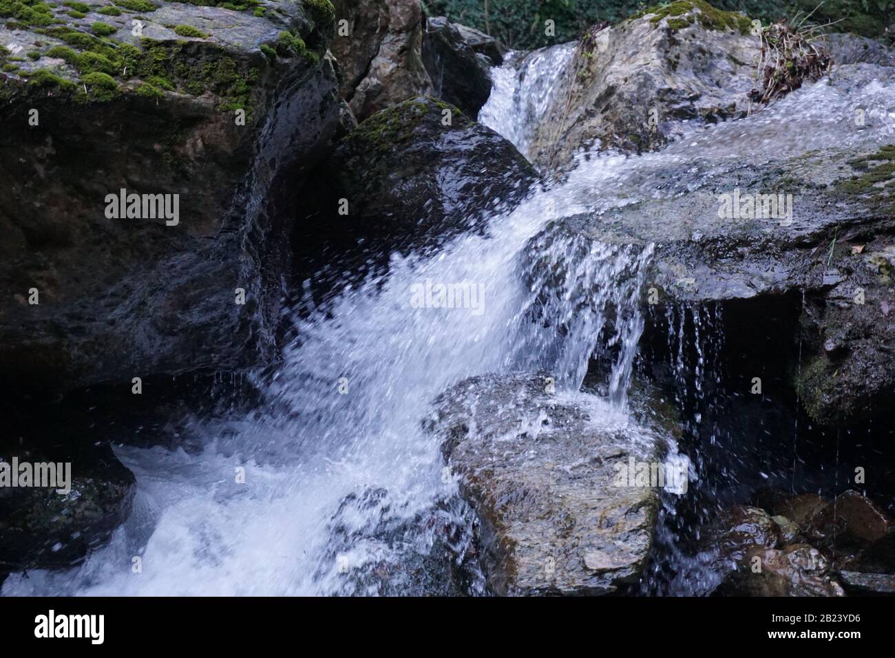 Water flows into a mountain river Stock Photo - Alamy