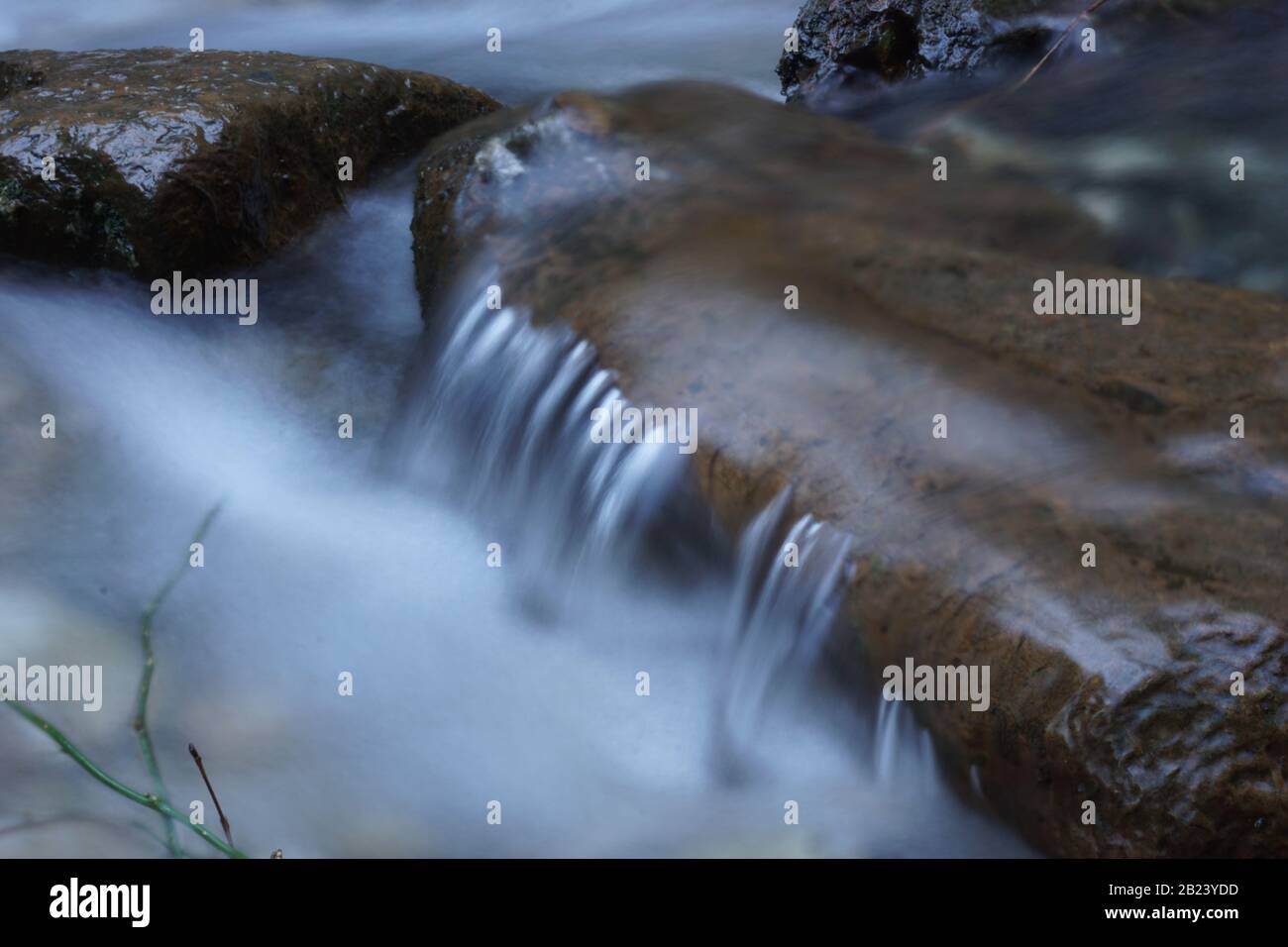 Water flows into a mountain river Stock Photo - Alamy