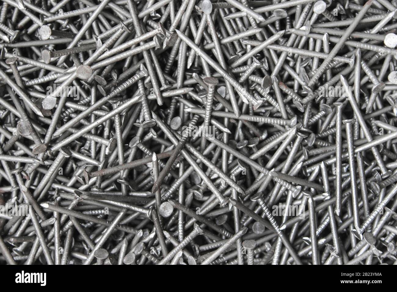 Steel nails scattered as a background Stock Photo - Alamy