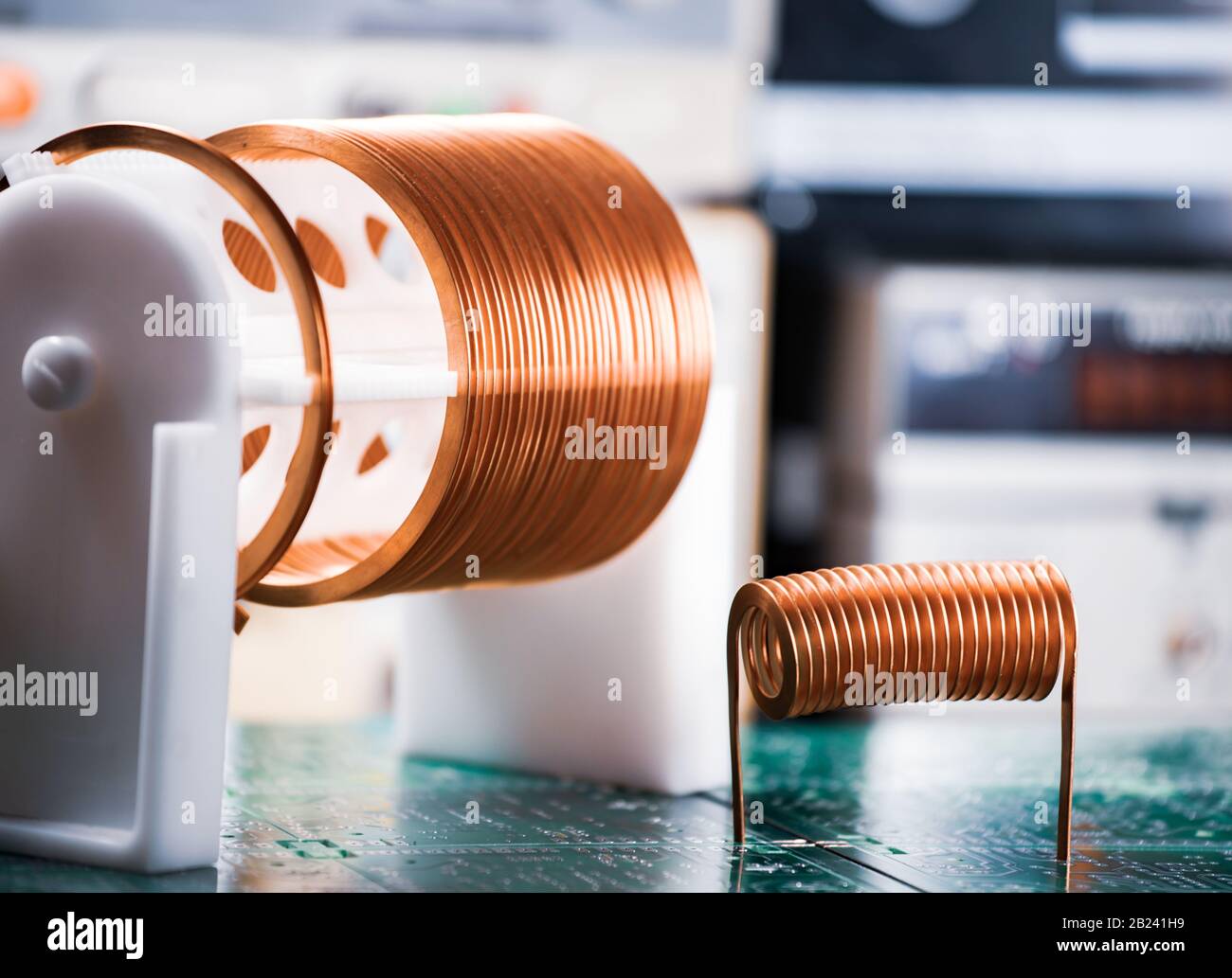 Close-up large and small coils with copper wire stand on a green ...