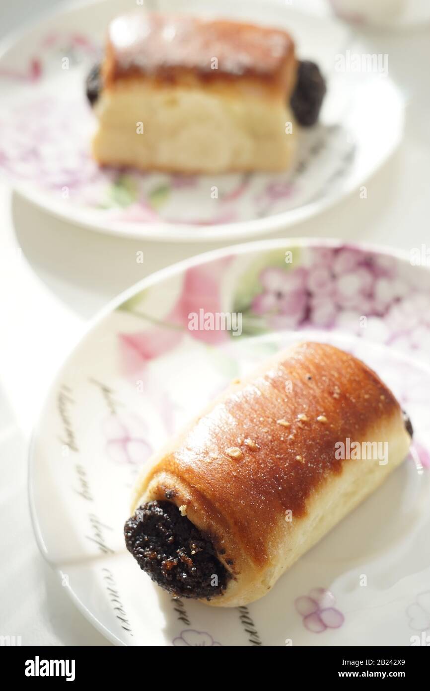 poppy buns in white romantic saucers on a table Stock Photo - Alamy
