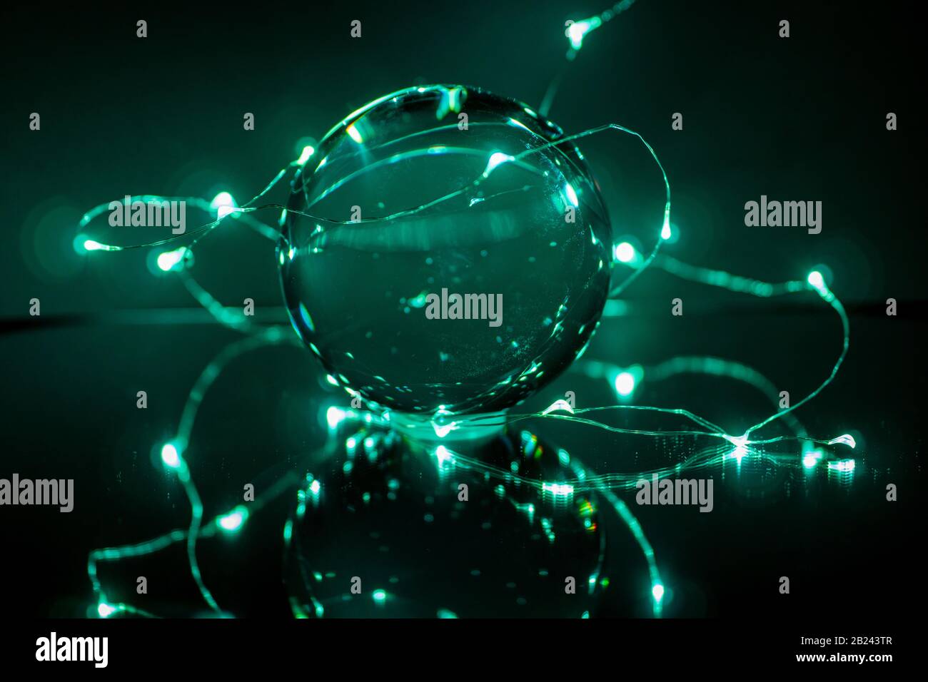 green lights surround a crystal clear glass sphere on a mirror Stock ...