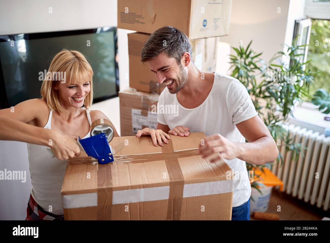 young couple packing things in boxes. packing, moving, concept Stock ...