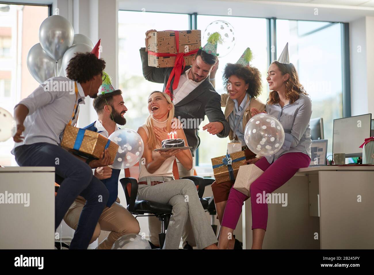 Happy young people celebrating birthday together at work Stock Photo ...
