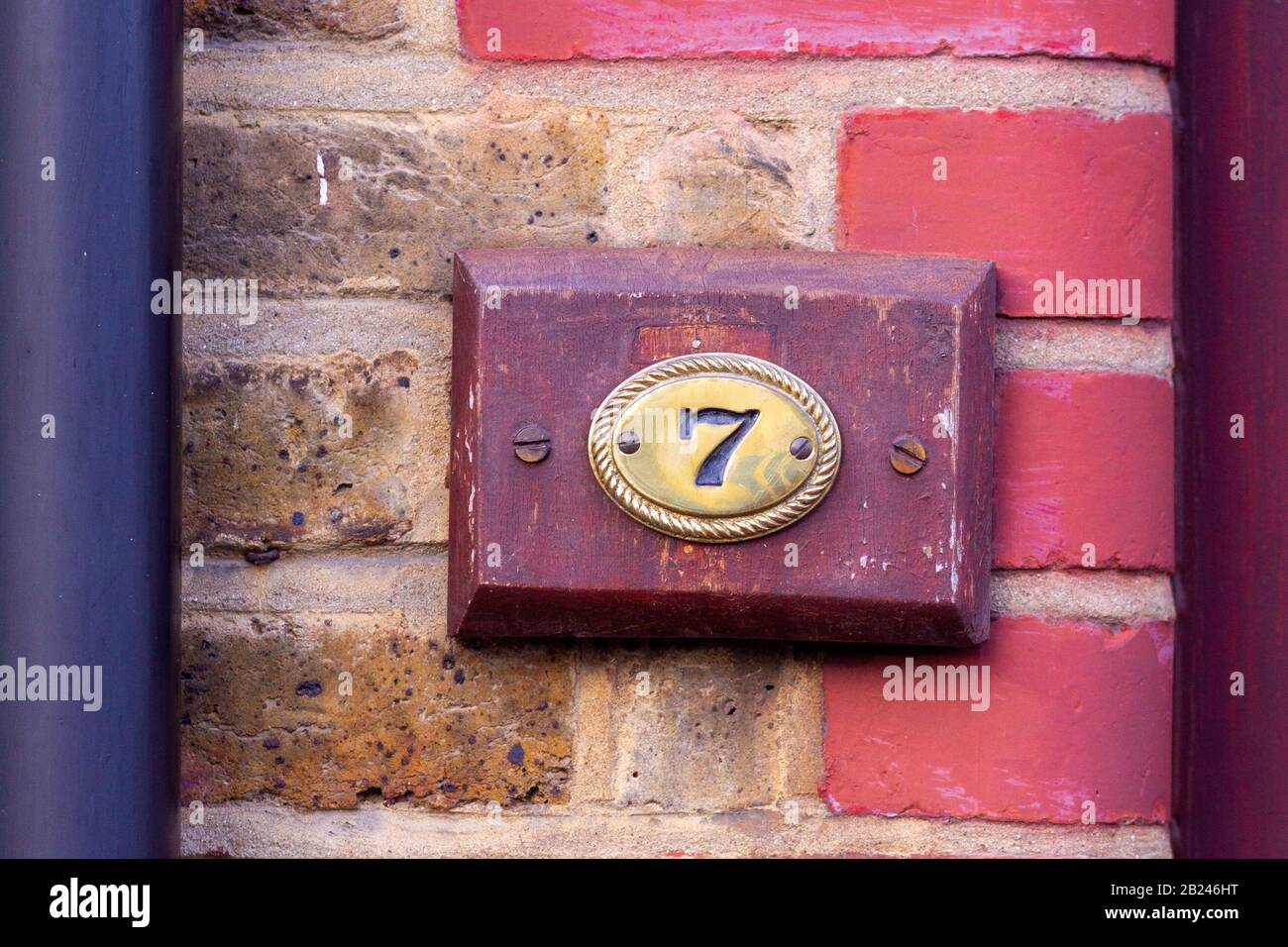 Wooden sign on a brick wall with the house number 7 Stock Photo - Alamy