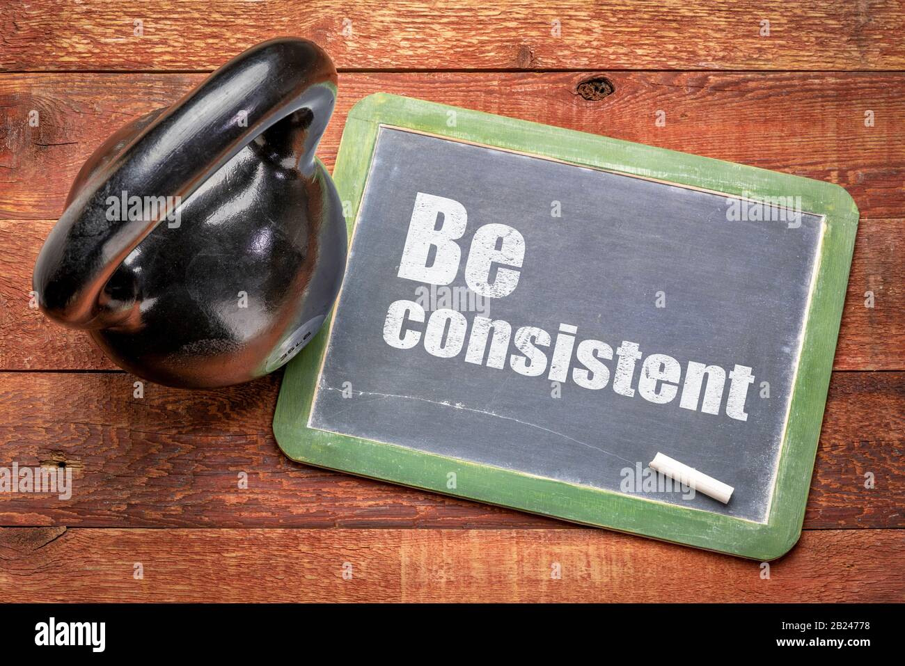 be consistent inspirational text on a slate blackboard with a ...