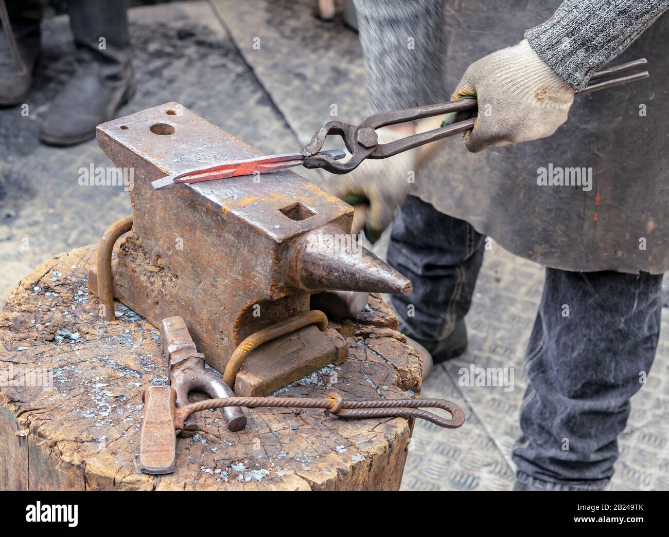 Blacksmith works with red-hot metal on the anvil Stock Photo - Alamy