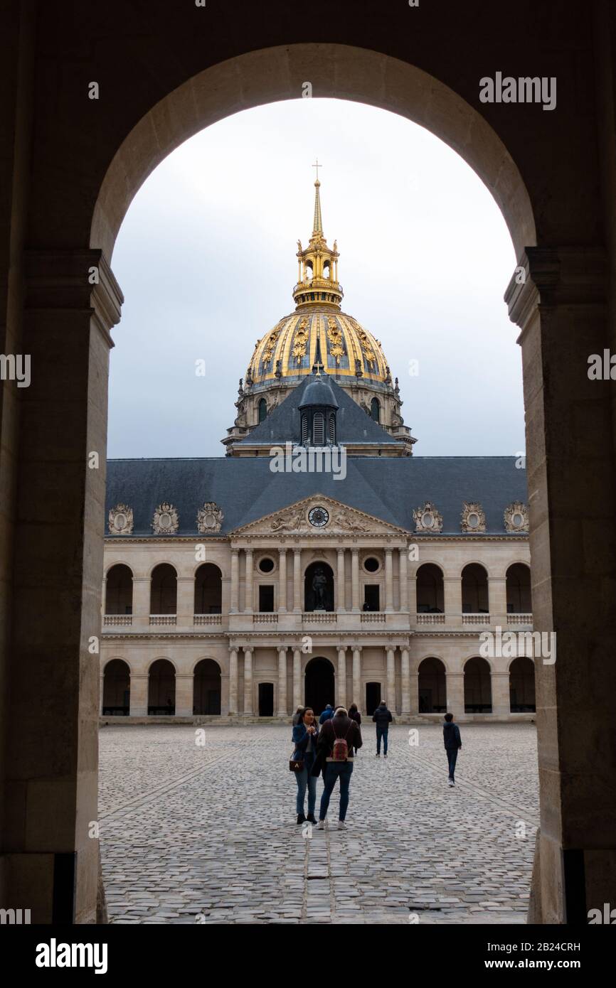 The golden dome of Les Invalides viewed from under the entrance archway ...
