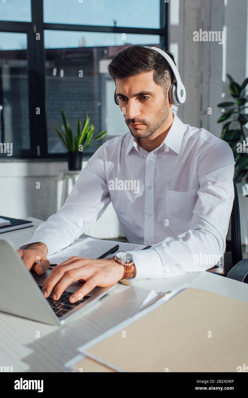 male translator working online with headphones and laptop Stock Photo ...