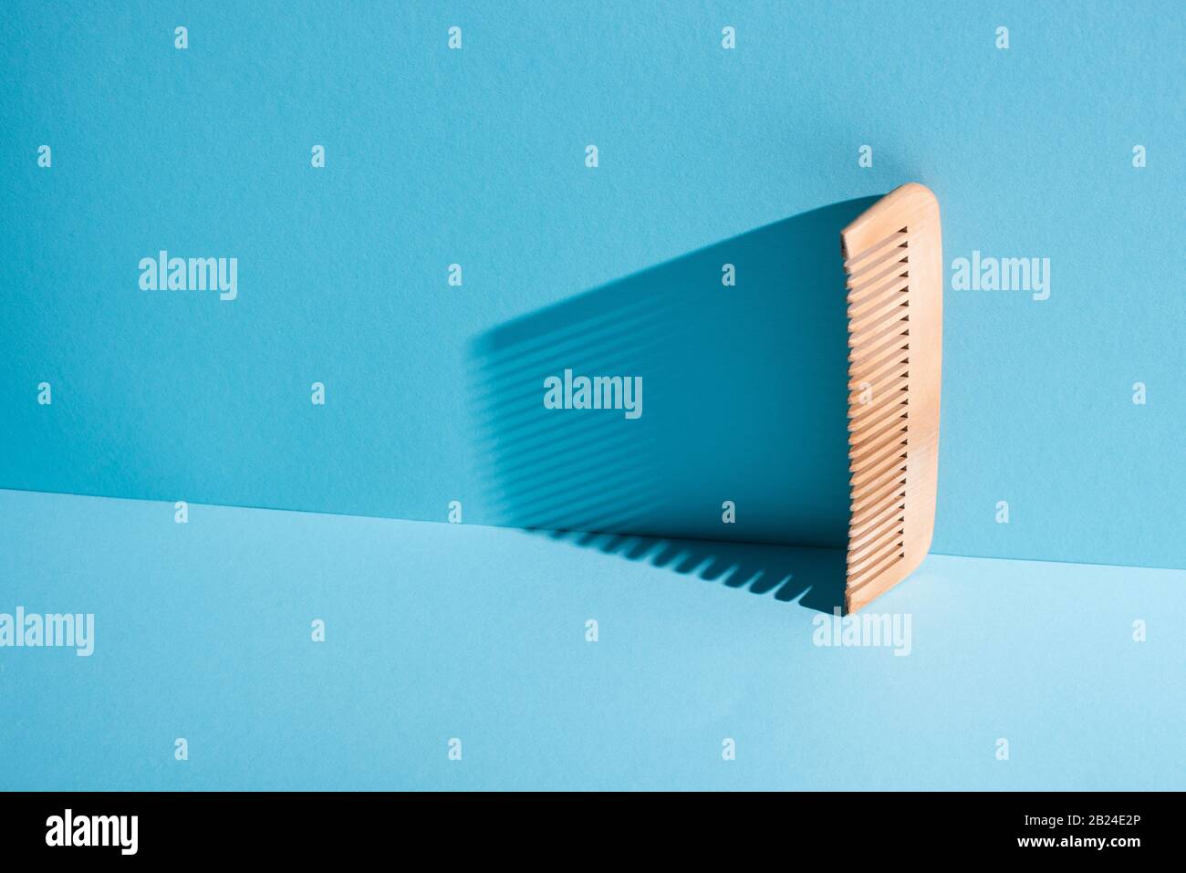 Wooden comb with shadow on blue background, zero waste concept Stock ...