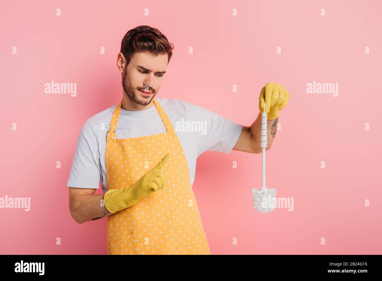 displeased young man in apron and rubber gloves showing refusal gesture ... displeased young man in apron and rubber gloves showing refusal gesture ...